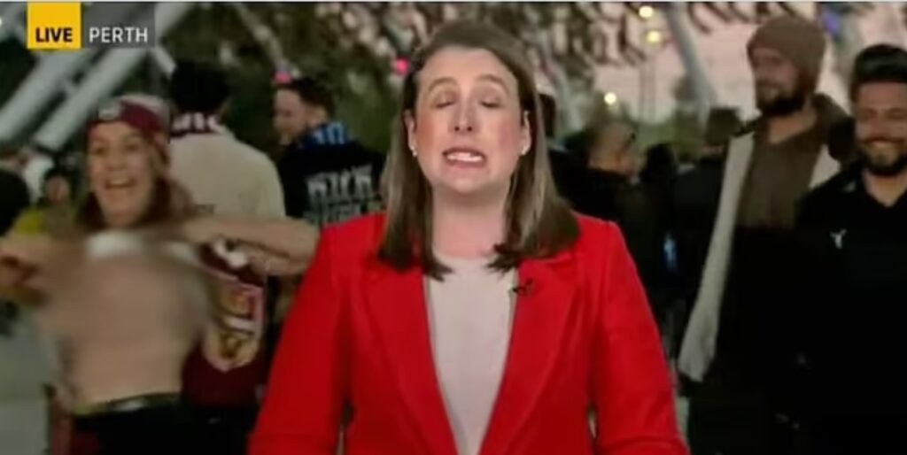 Female State of Origin fan flashes the camera while reporter does a ...